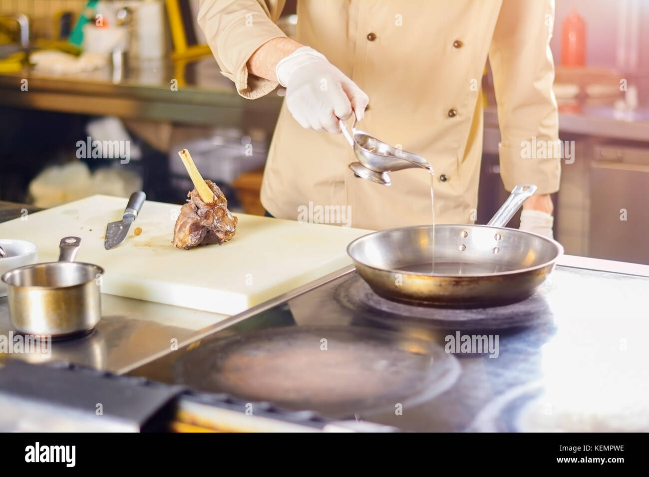 Chef pouring cooking oil into frying pan. Chef in restaurant going to ...