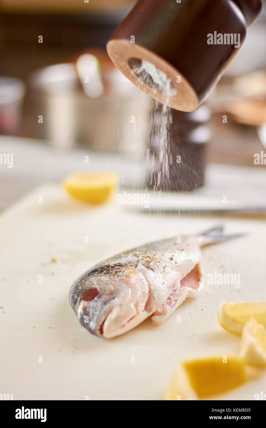 Processing with salt raw fish. Process of cooking dorado fish with ...