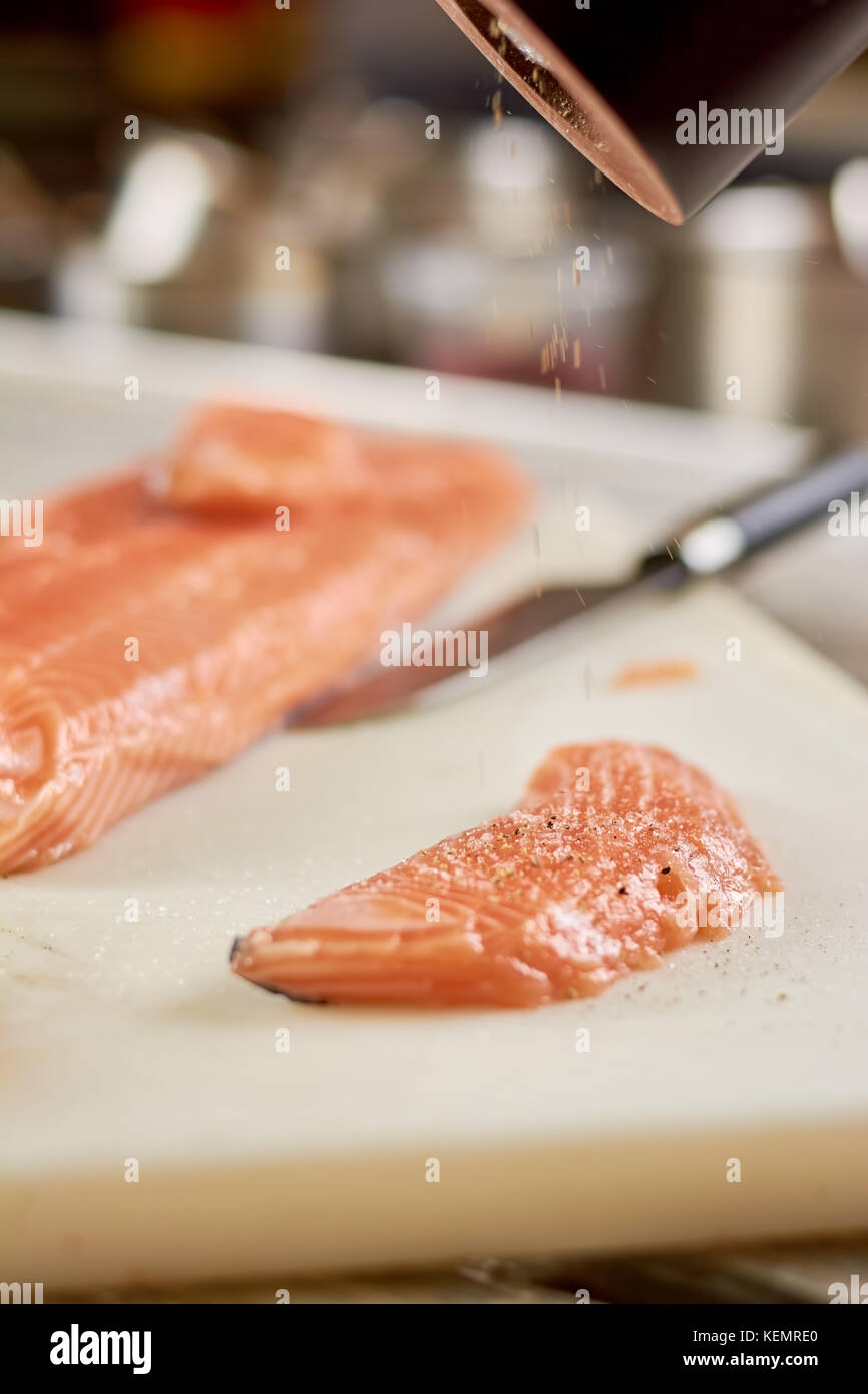 Piece of raw salmon sprinkling with spices. Fresh salmon cooking ...