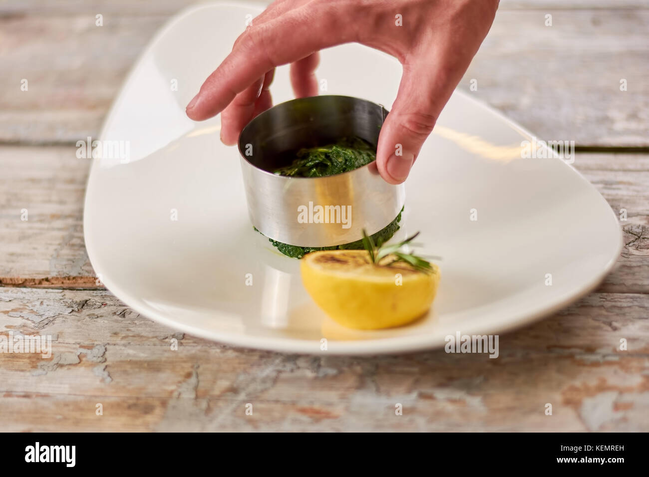Chef hand forming a dish. Chef hand serving an appetizer with metl ring ...