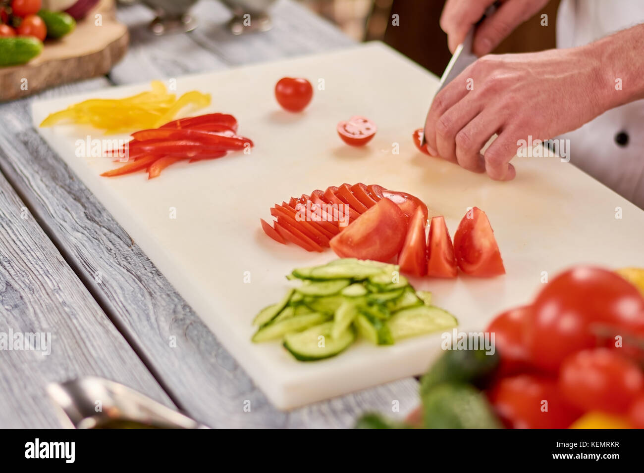 The process of cutting vegetables on white board. Male chef hands ...