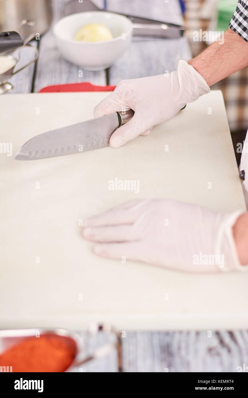 Chef with knife and cutting board. Male chef hands holding knife on ...