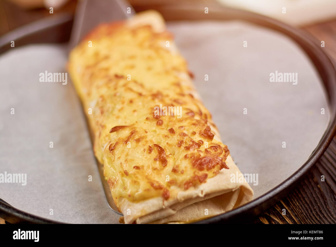 Appetizing burrito baked with cheese. Burrito cooking process. Mexican ...