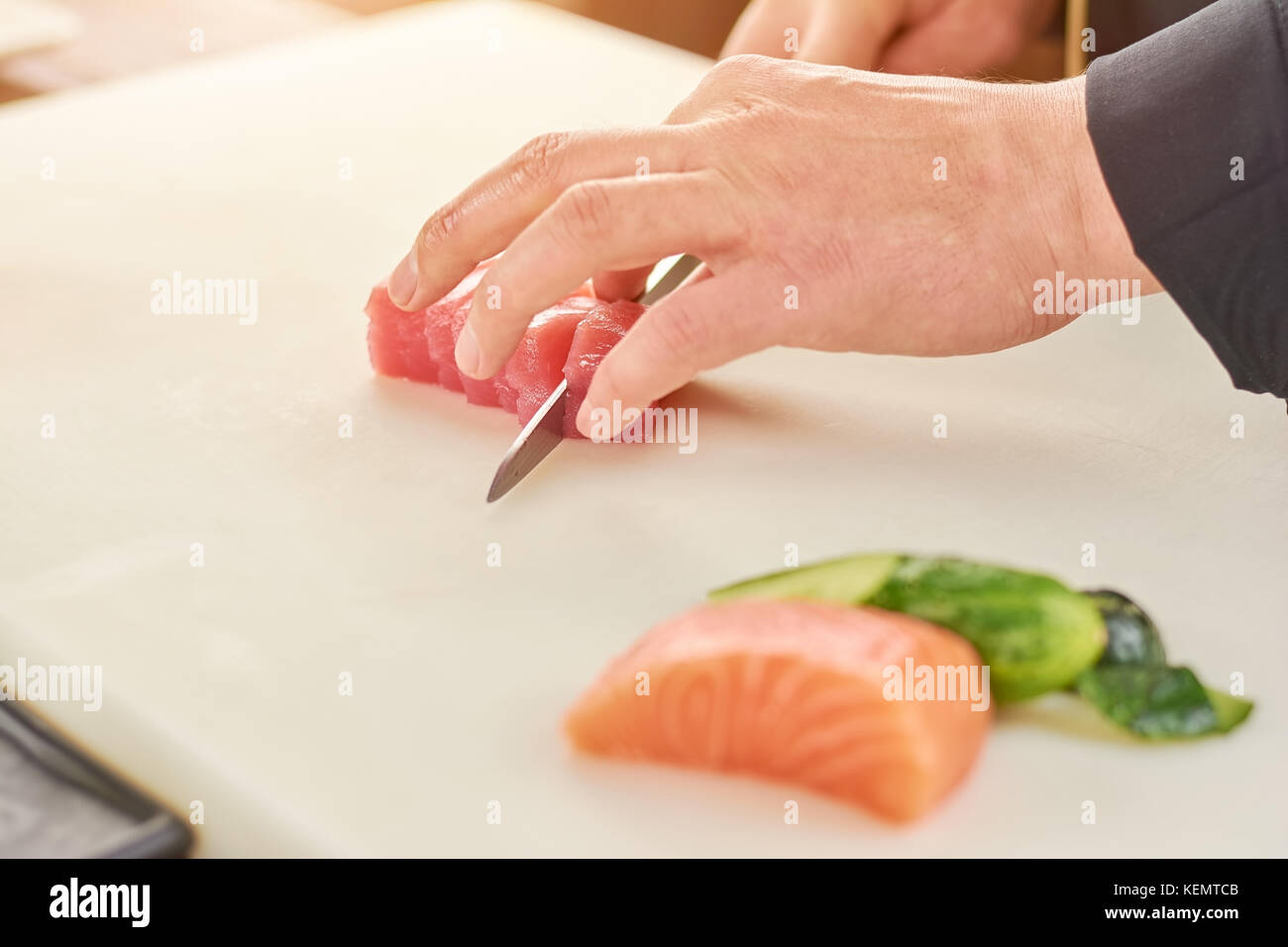 Chef cutting fresh tuna in small pieces. The process of slicing raw ...