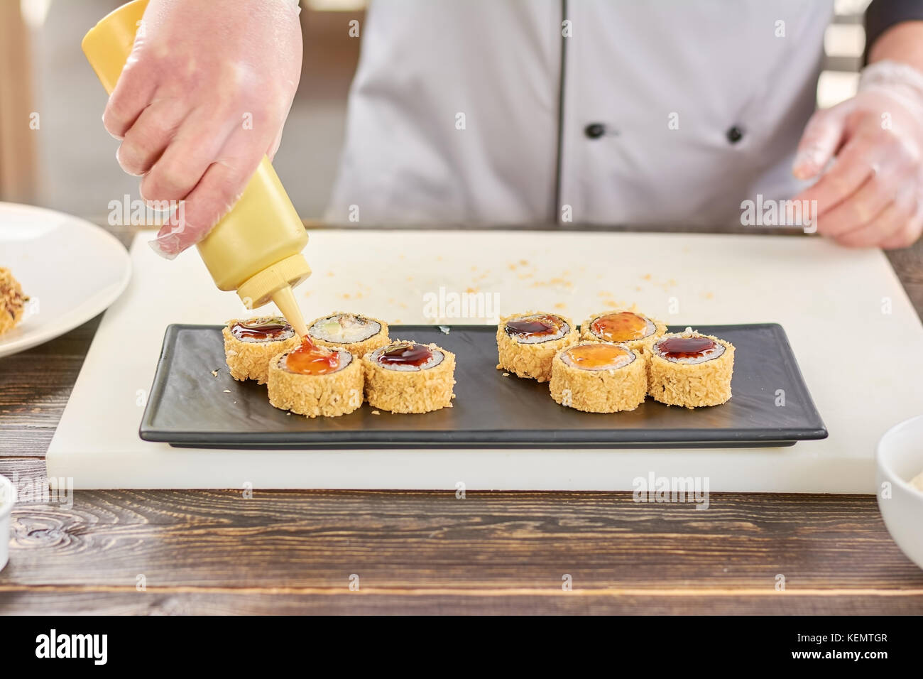 Chef pouring sushi with sauce. Preparation of delicious japanese sushi ...