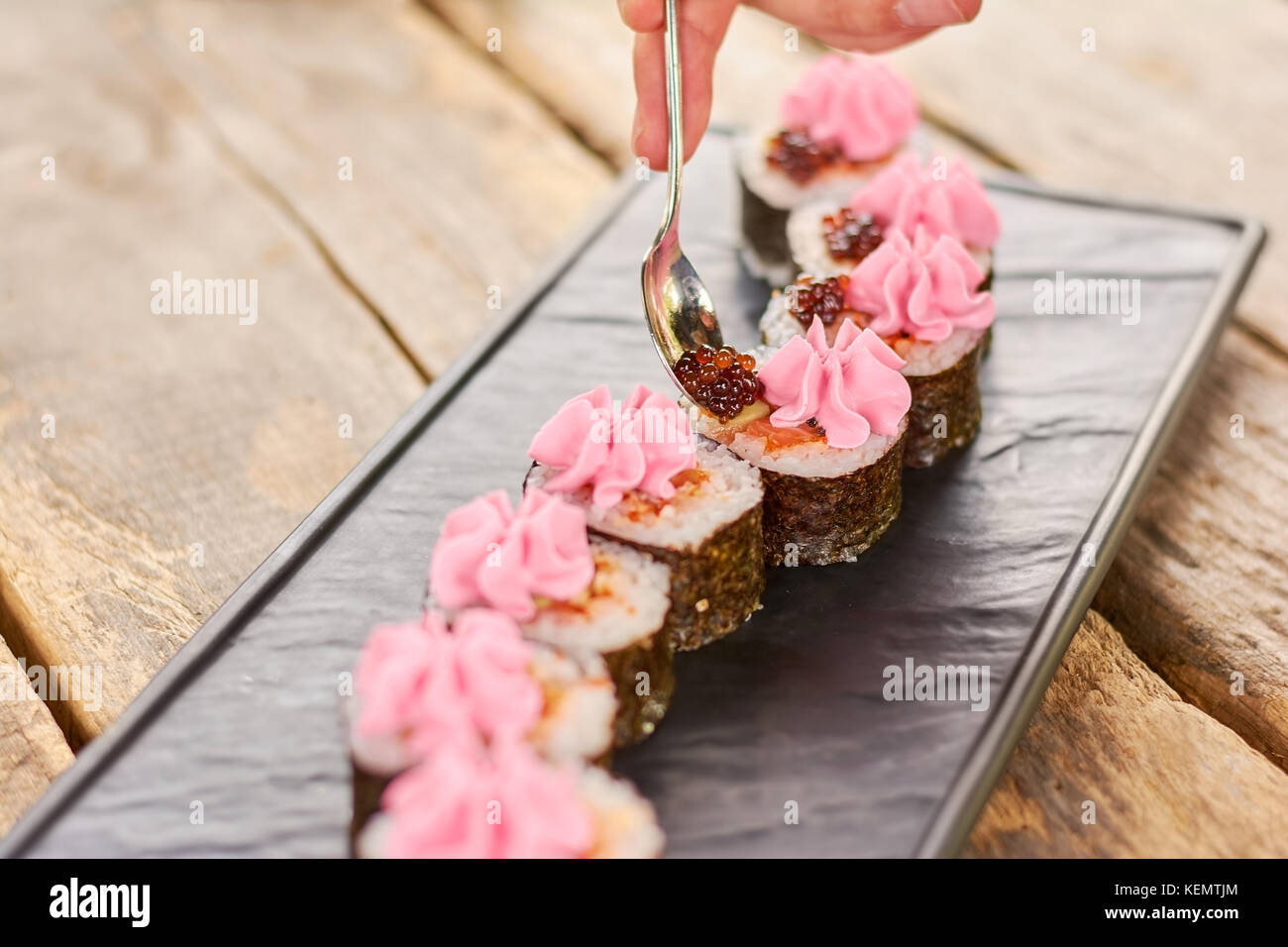 The process of sushi decorating with caviar. Appetizing japanese sushi ...