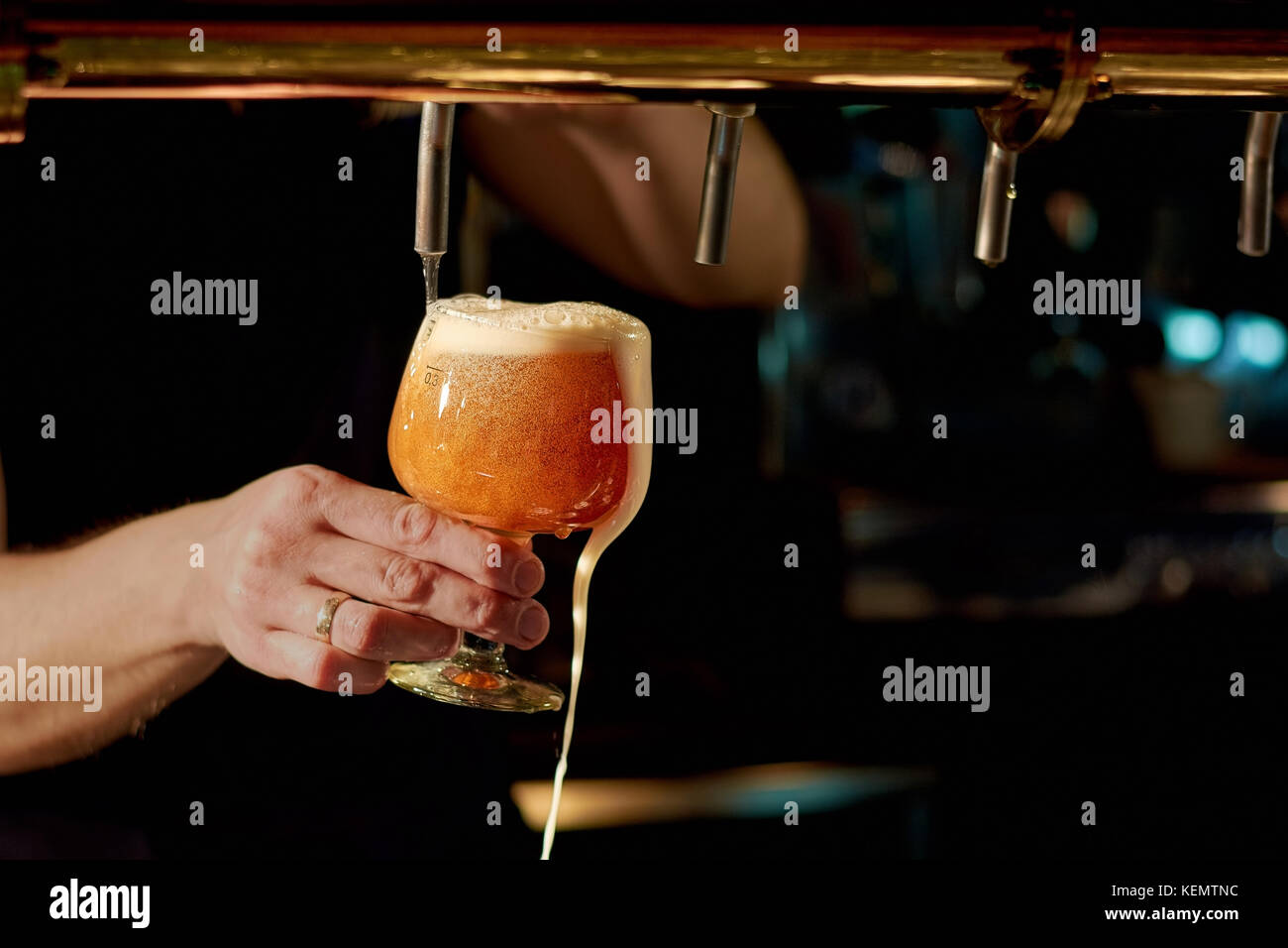 Close up of waiter hand pouring beer. Close up hand of man pouring ...