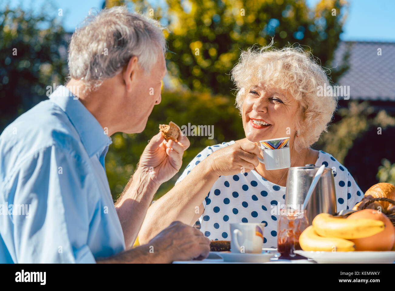 Happy elderly couple eating breakfast in their garden outdoors i Stock ...