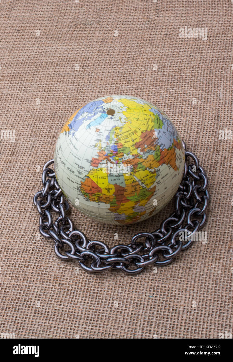 Chain around globe placed on canvas background Stock Photo - Alamy