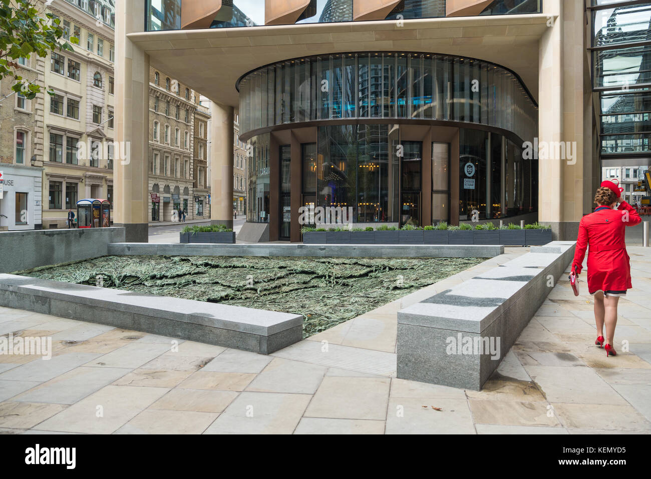 Woman dressed in red walks by the Bloomberg European headquarters in ...