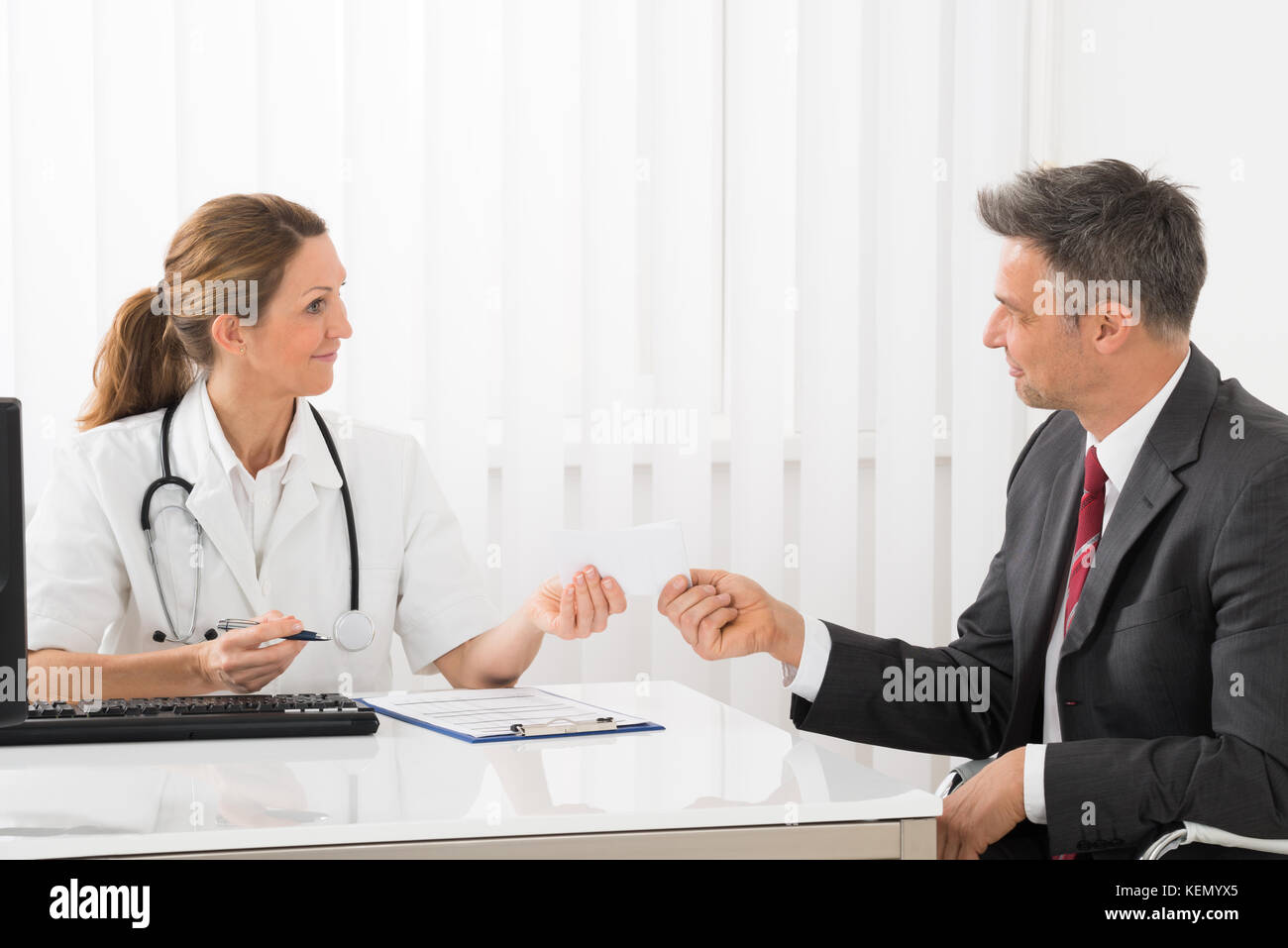 Female Doctor Giving Prescription Paper To Mature Businessman Stock ...