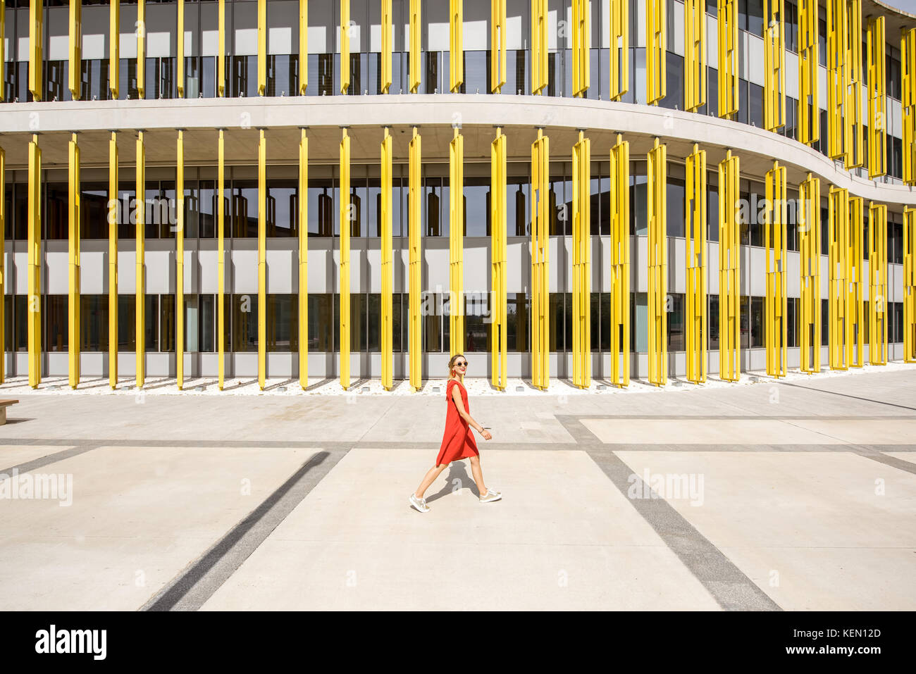 Woman on the yellow building background Stock Photo - Alamy