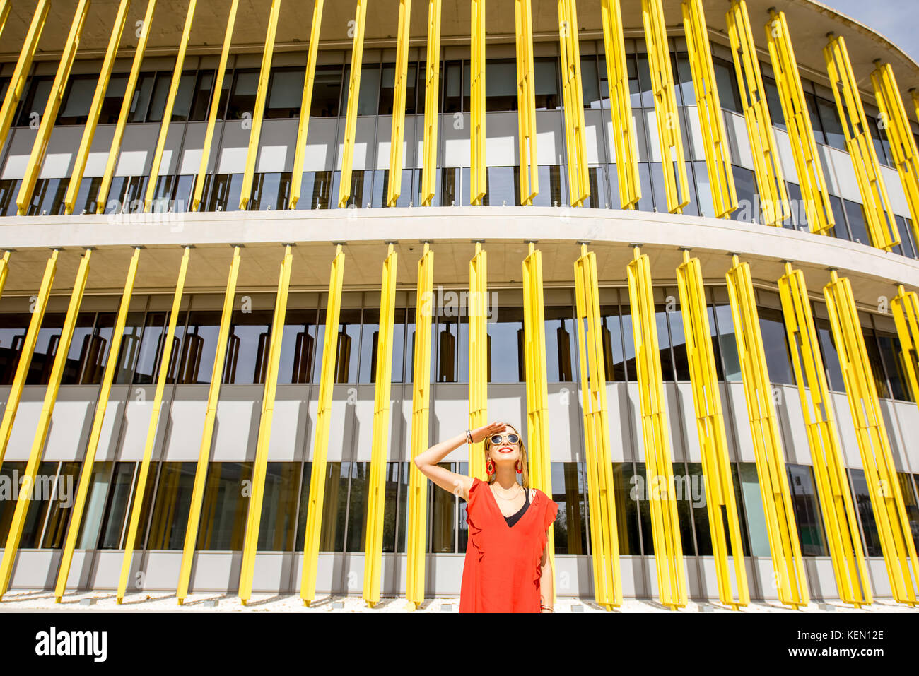 Woman on the yellow building background Stock Photo - Alamy
