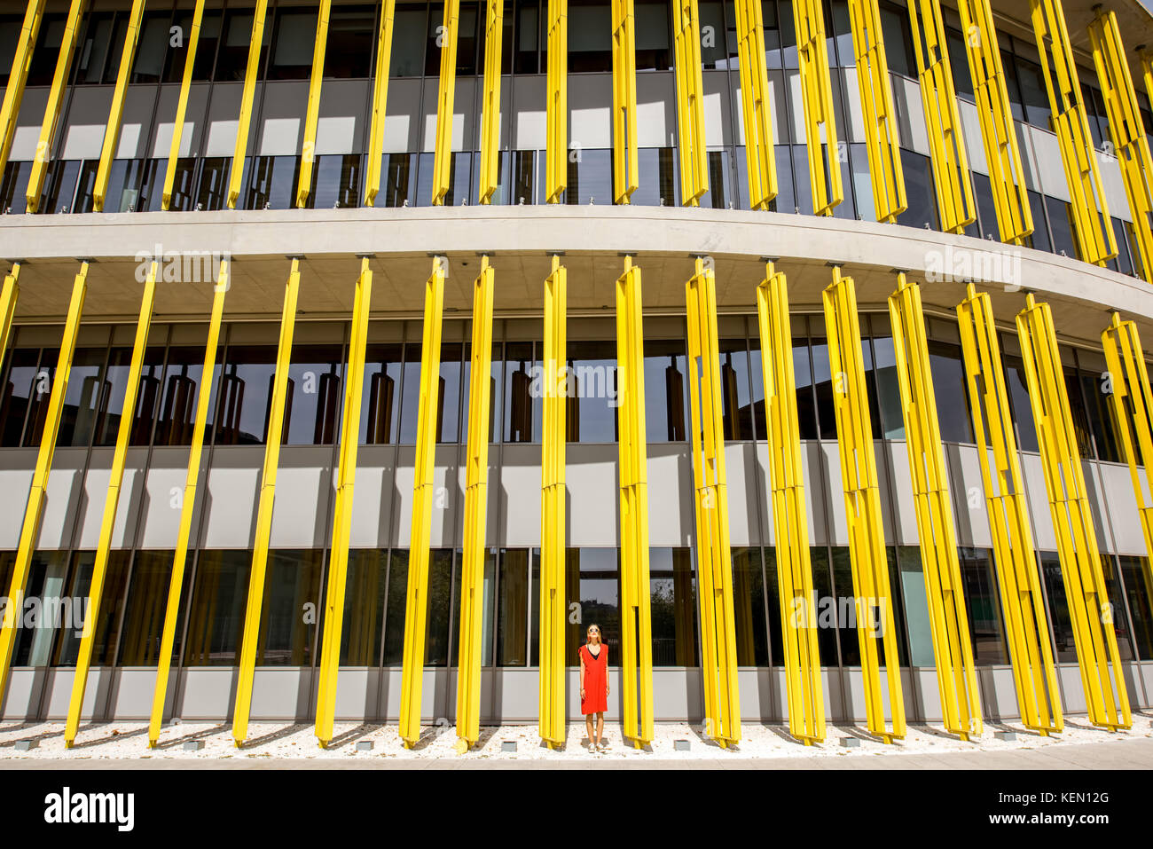 Woman on the yellow building background Stock Photo - Alamy