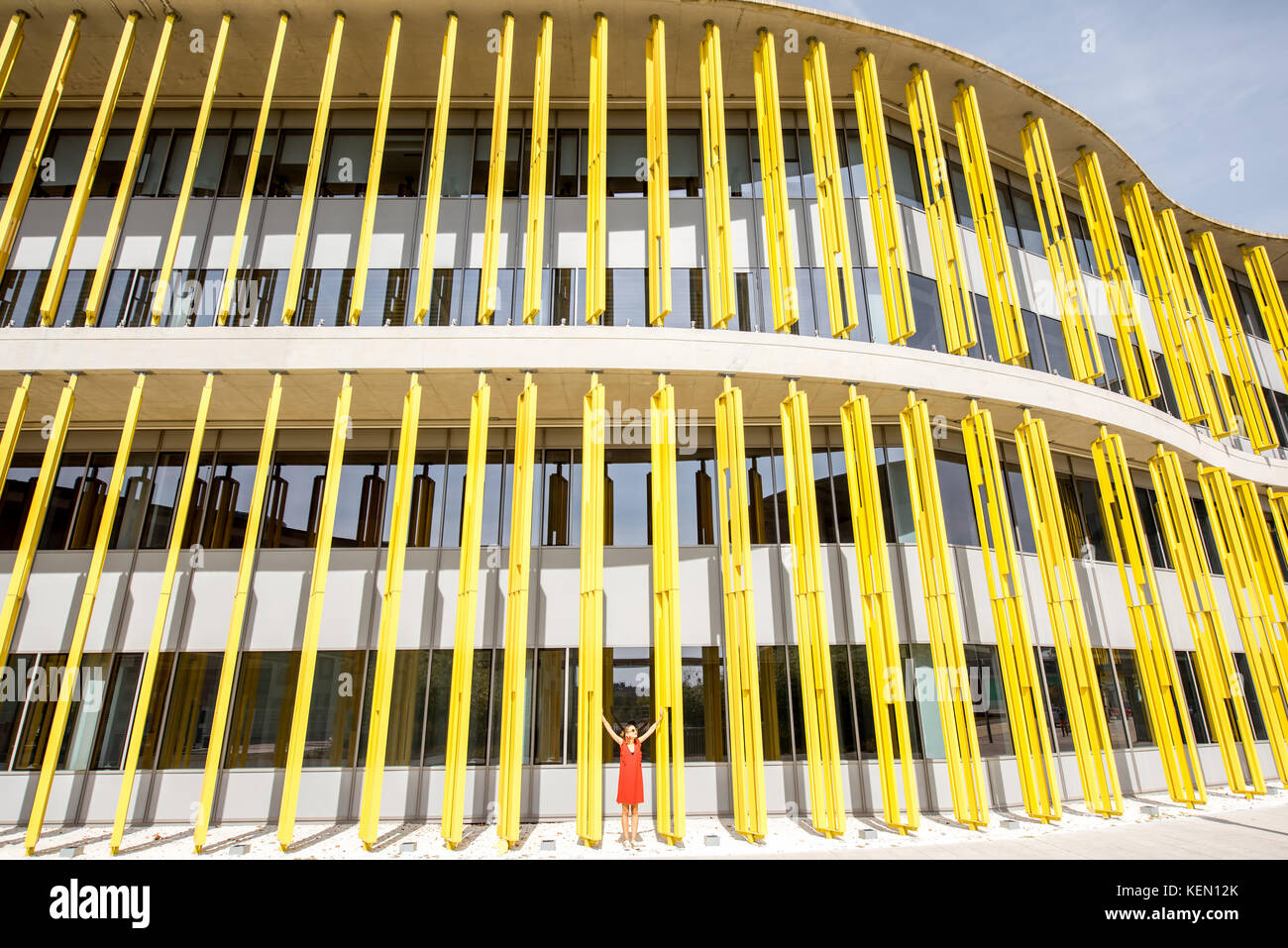 Woman on the yellow building background Stock Photo - Alamy
