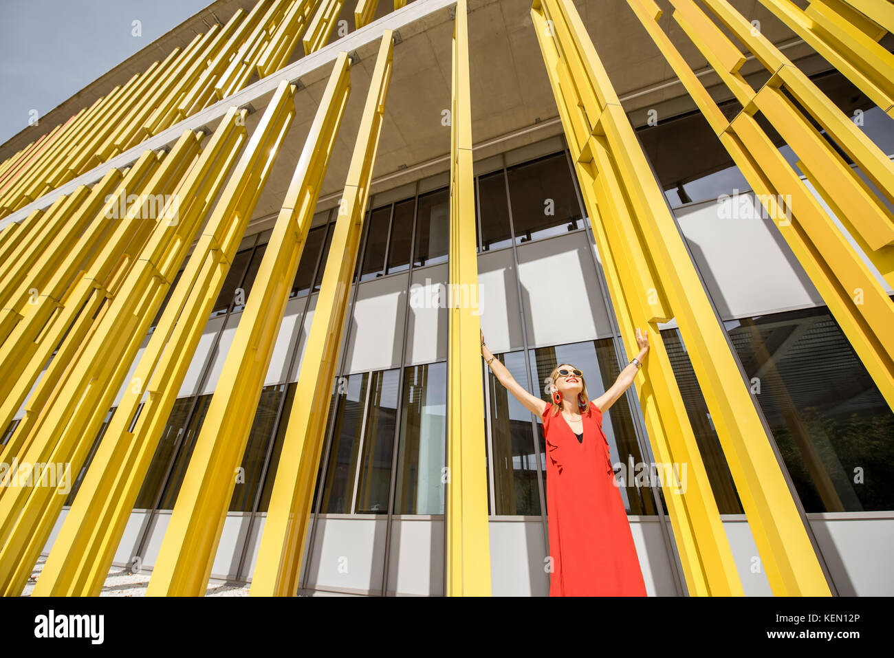 Woman on the yellow building background Stock Photo - Alamy