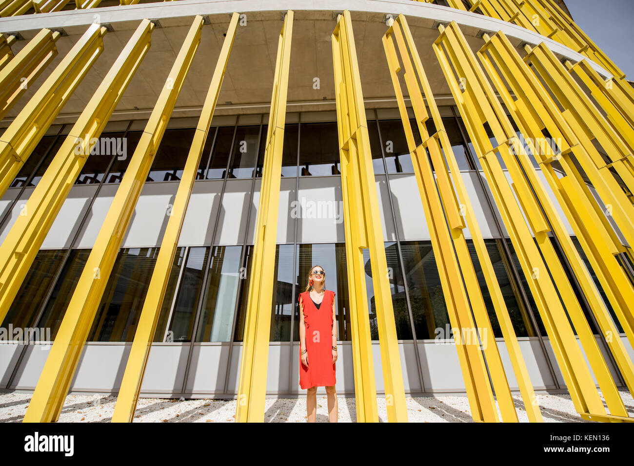 Woman on the yellow building background Stock Photo - Alamy