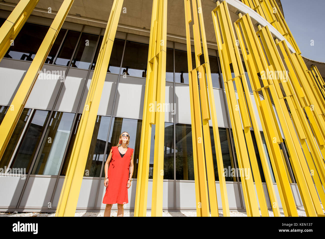 Woman on the yellow building background Stock Photo - Alamy