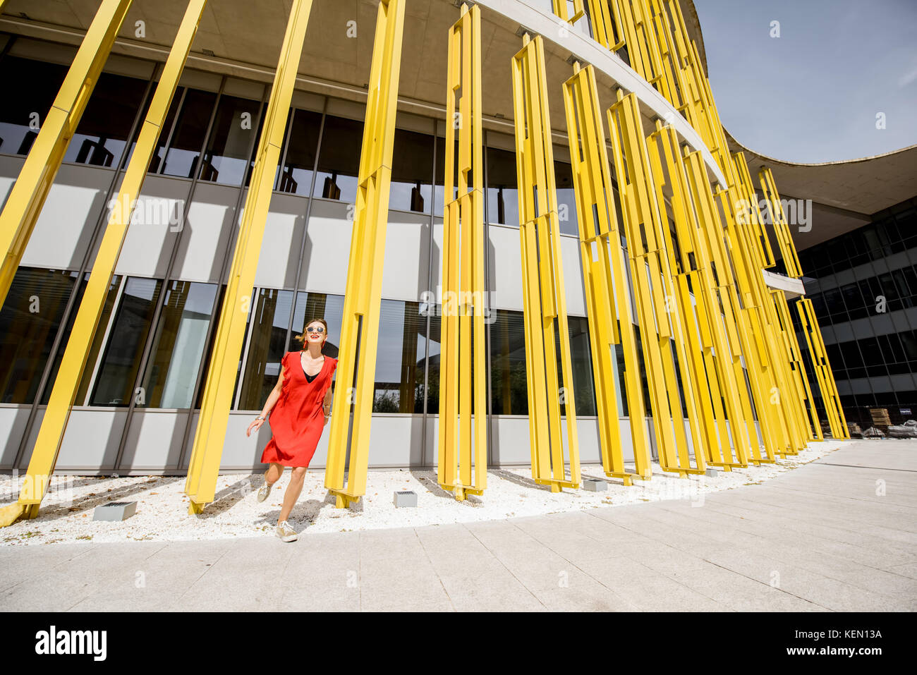 Woman on the yellow building background Stock Photo - Alamy