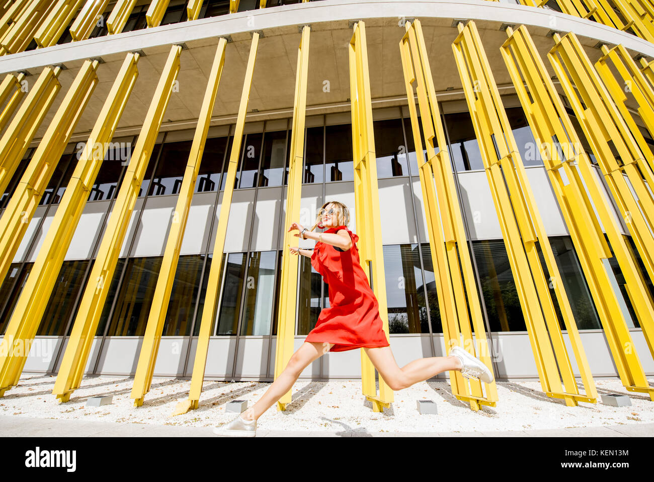 Woman on the yellow building background Stock Photo - Alamy
