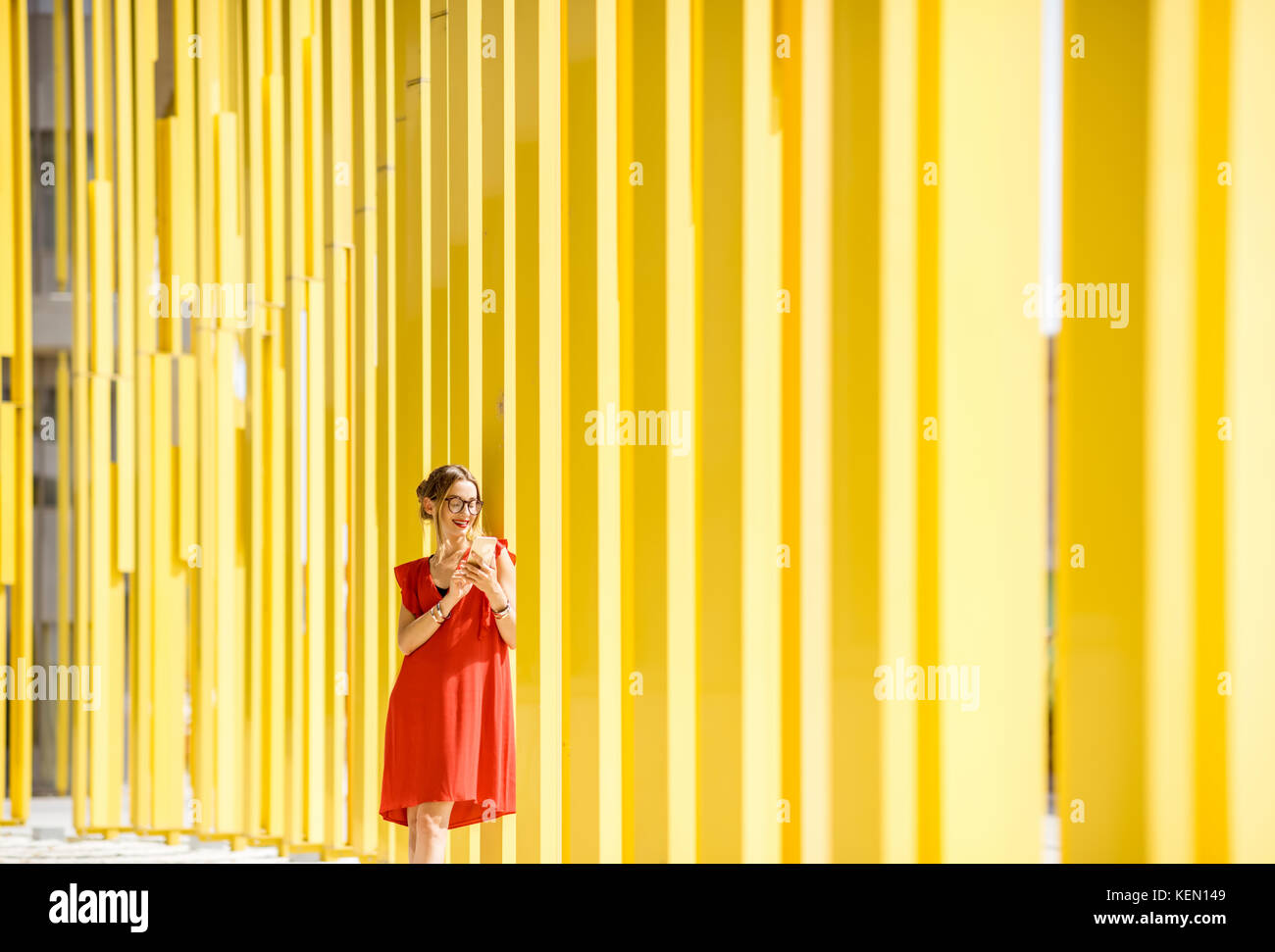 Woman on the yellow building background Stock Photo - Alamy