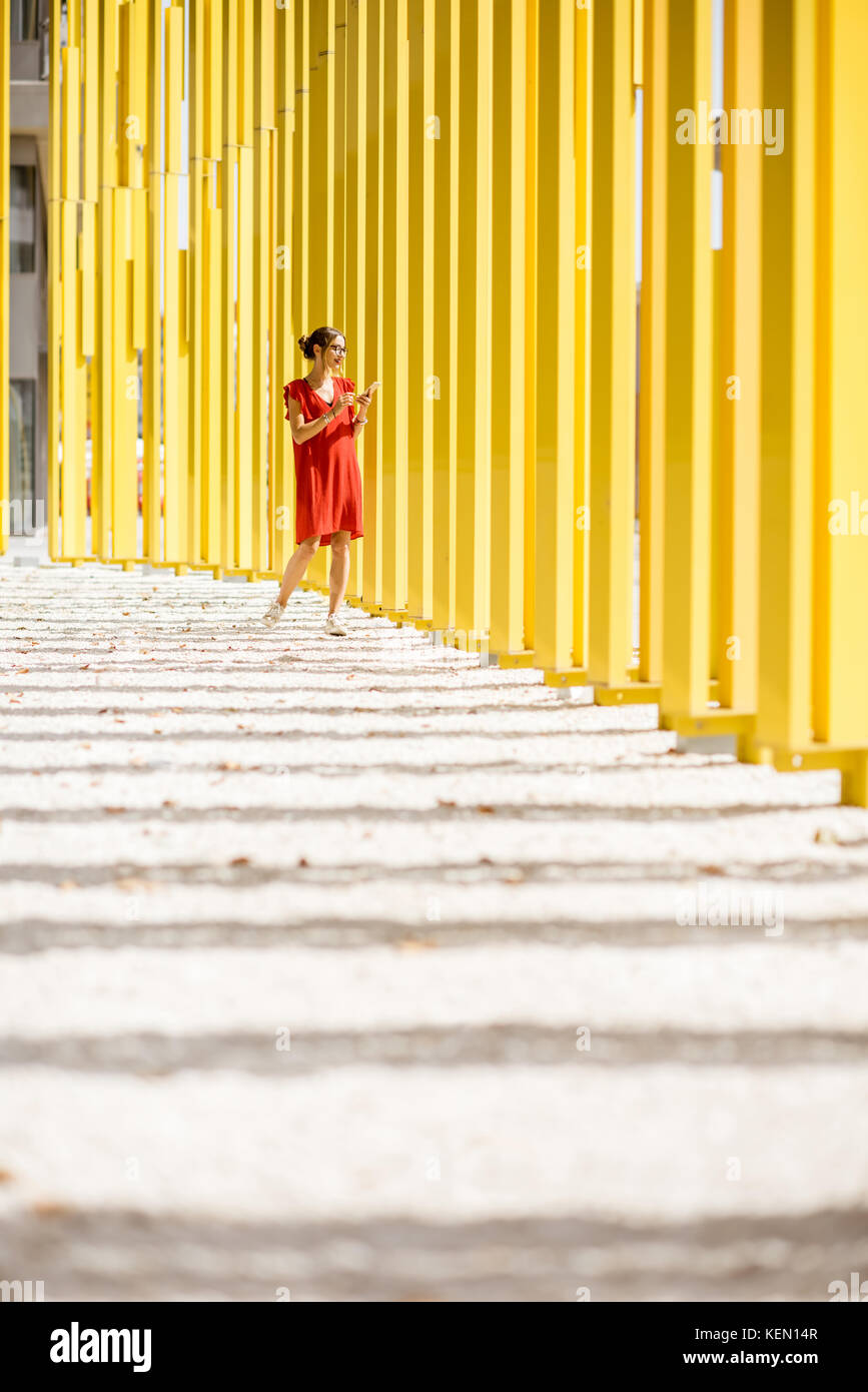 Woman on the yellow building background Stock Photo - Alamy