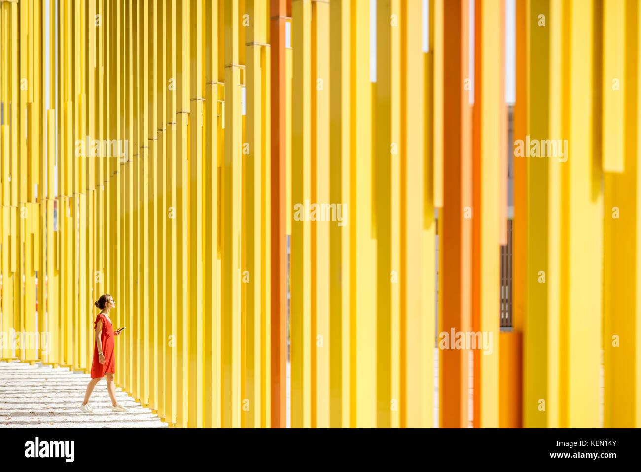 Woman on the yellow building background Stock Photo - Alamy