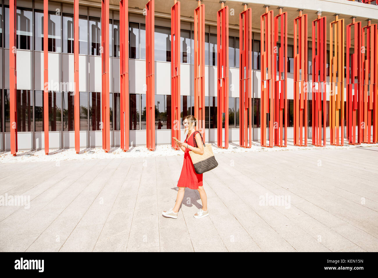Woman on the red wall background Stock Photo - Alamy