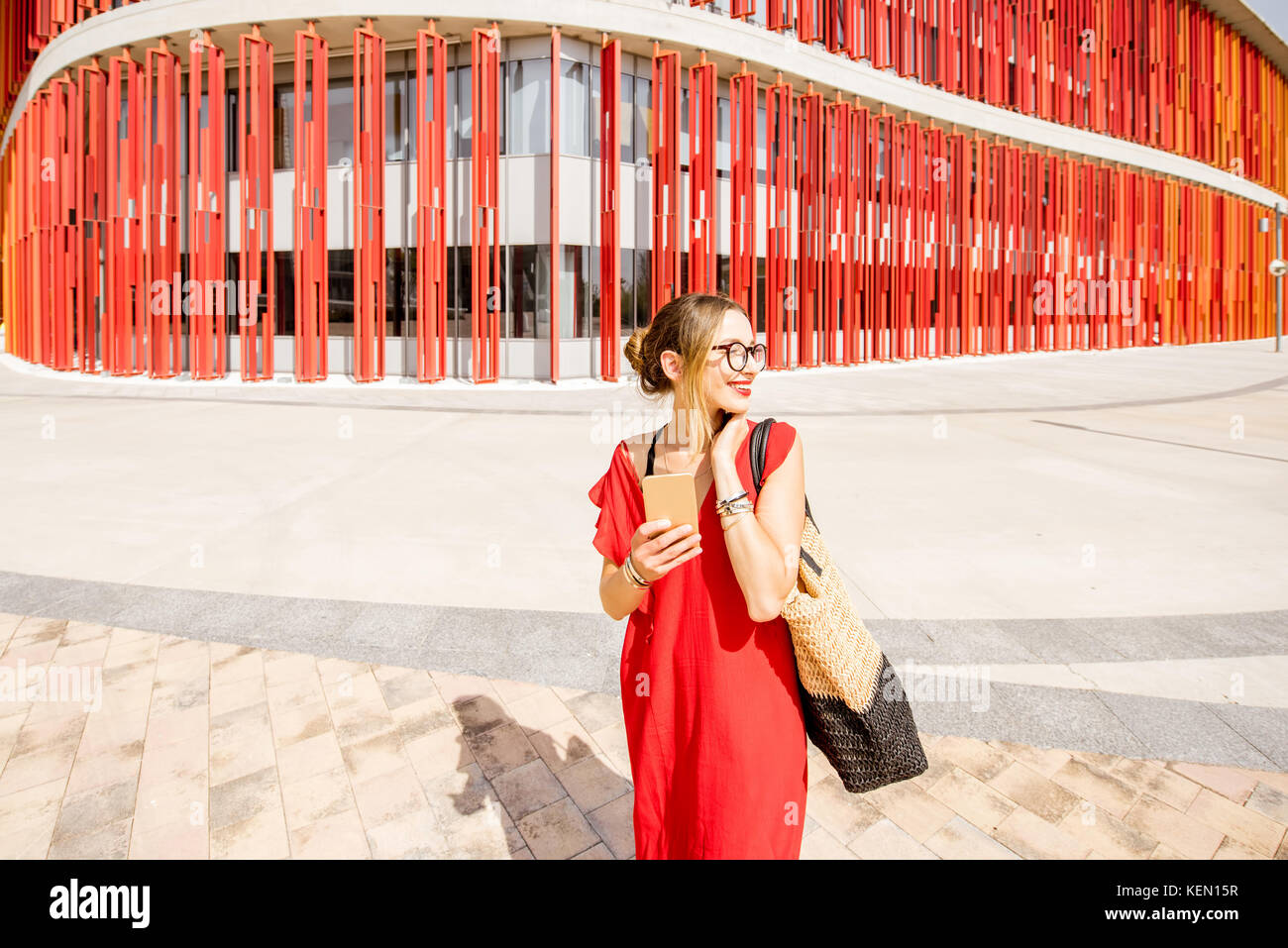 Woman on the red wall background Stock Photo - Alamy