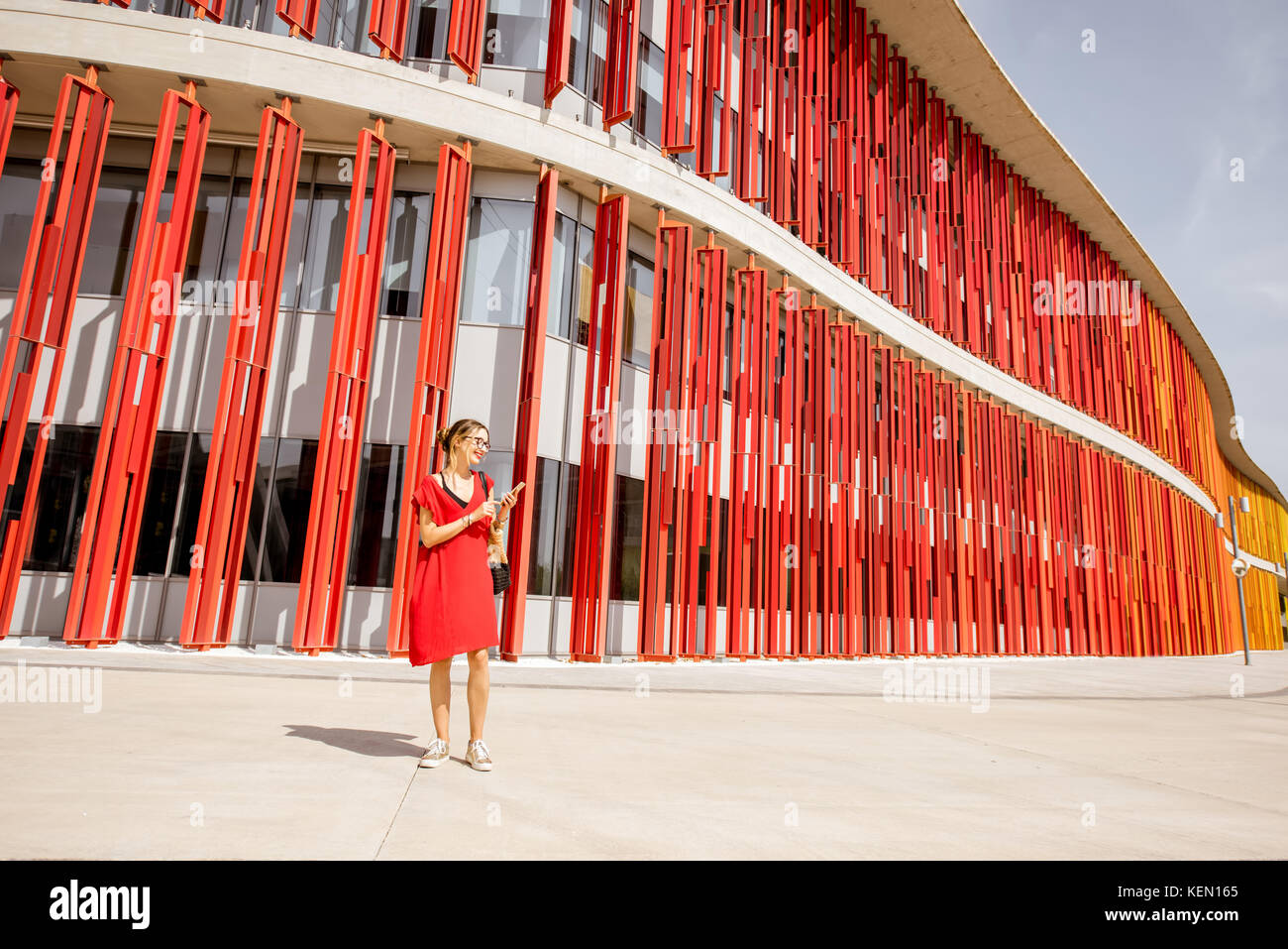 Woman on the red wall background Stock Photo - Alamy