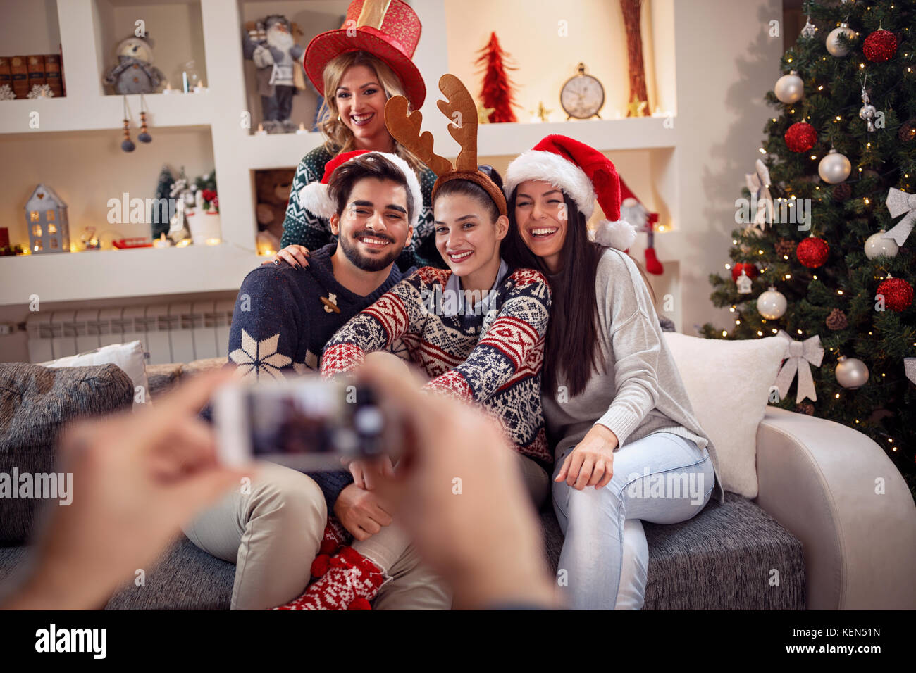photographing friends by phone for Christmas eve Stock Photo - Alamy