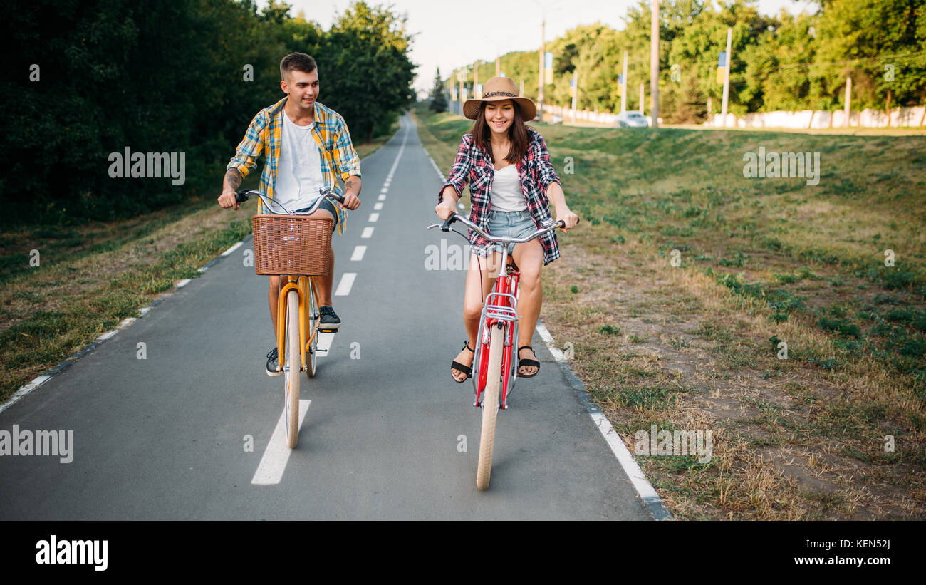 Love couple riding on retro bikes in summer park Stock Photo - Alamy