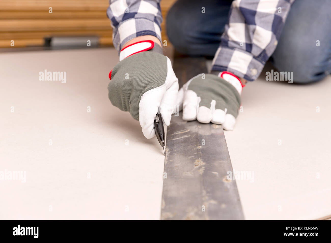 worker cutting plasterboard with construction knife. Attic renovation ...
