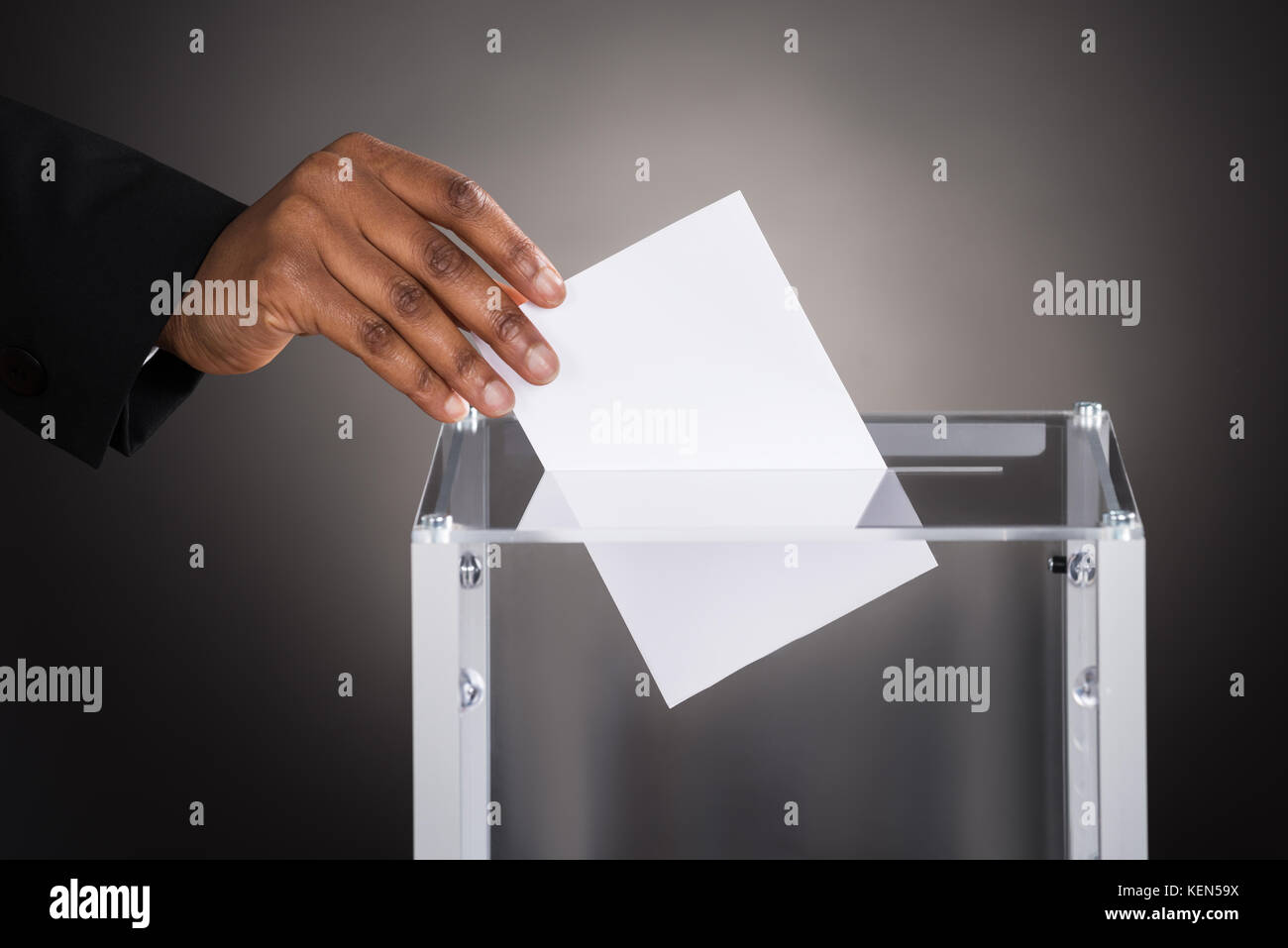 Close-up Of A Businessperson Hand Inserting Ballot In Glass Box Against ...