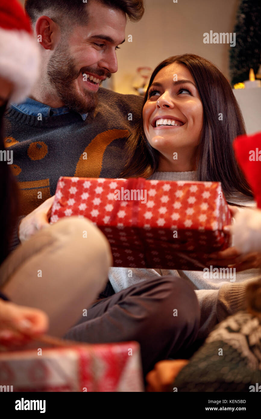 Cheerful romantic couple exchanging gift boxes at Christmas eve Stock ...