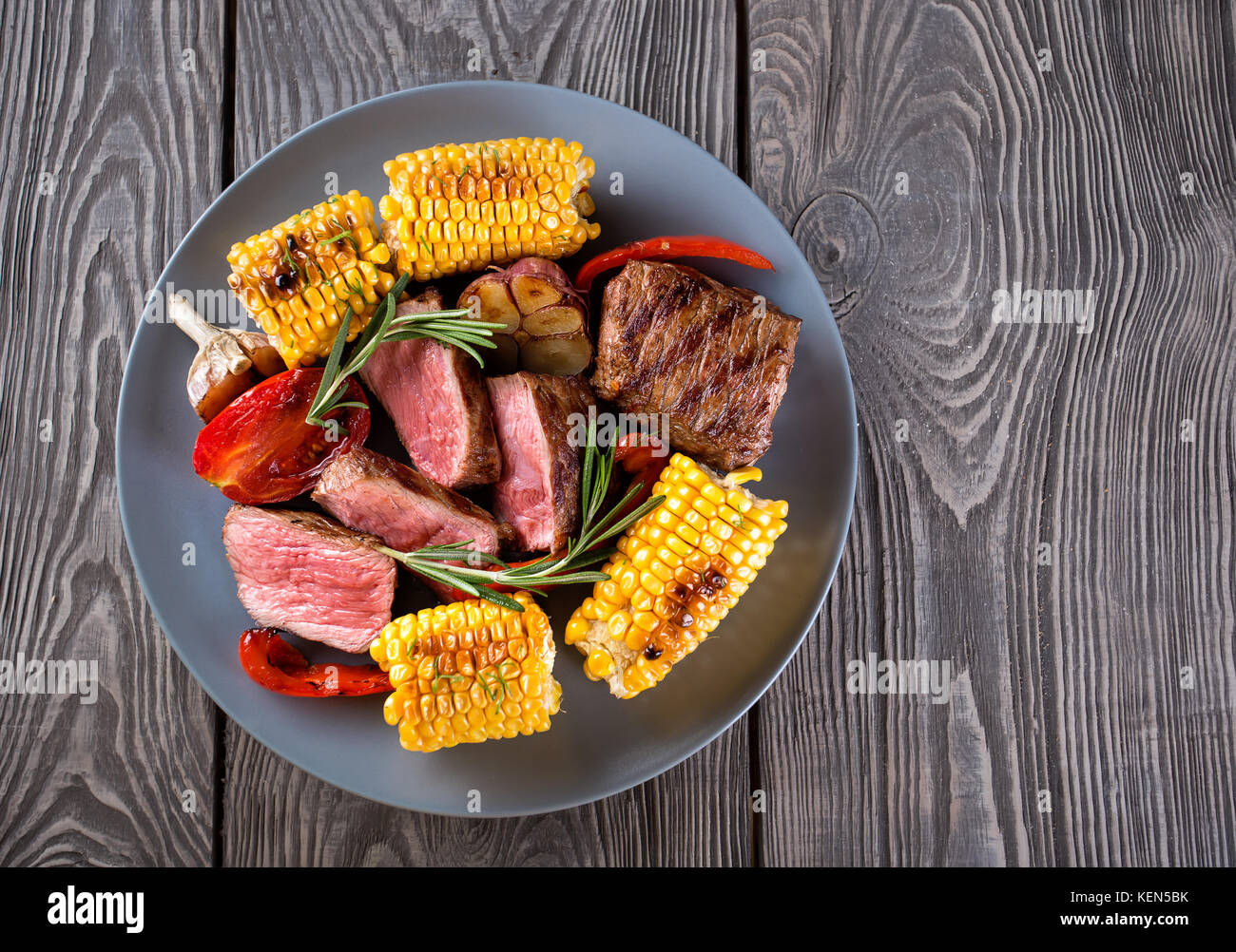Blue clay plate with pieces of poorly roasted meat and vegetables ...