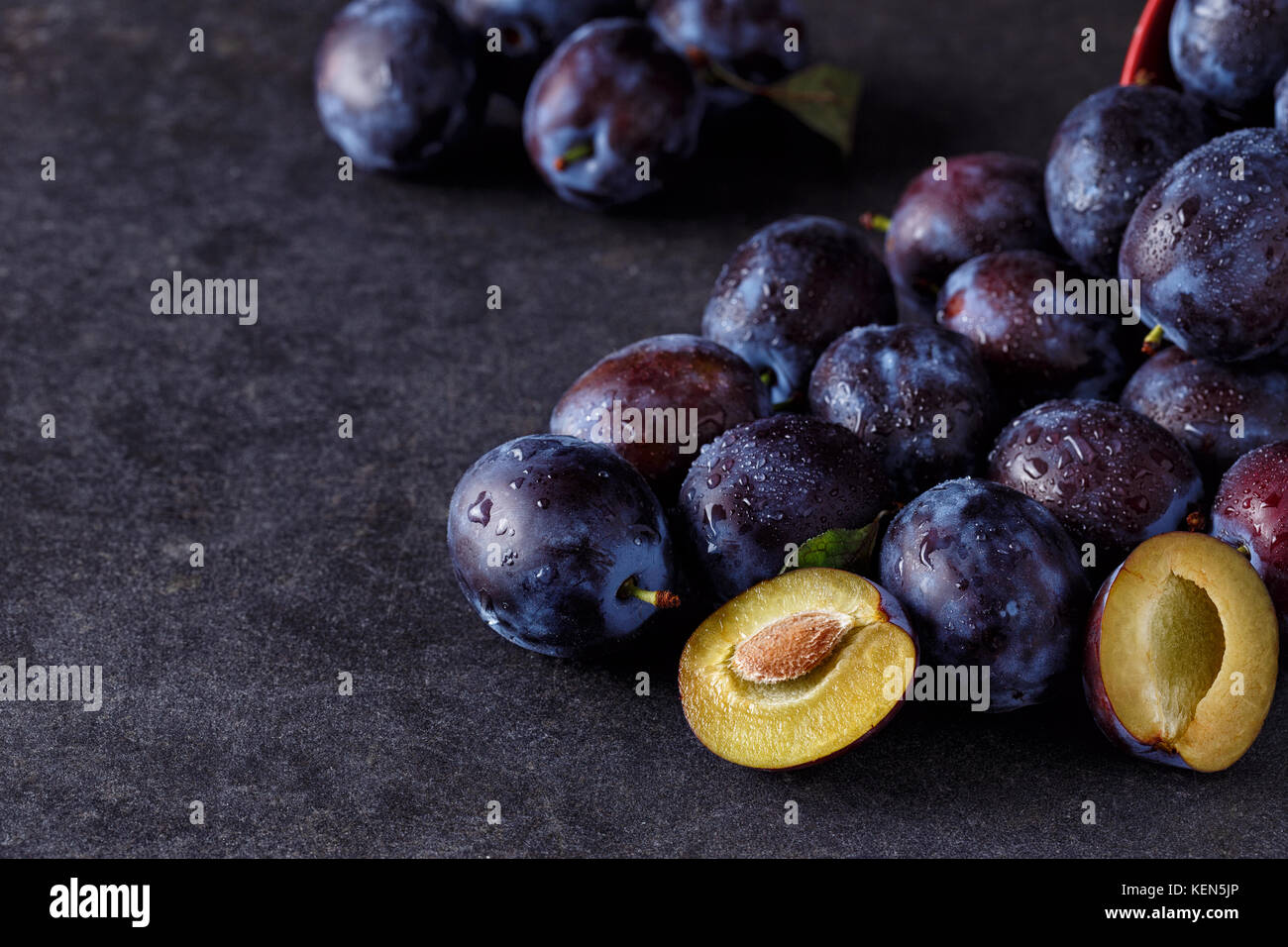 Fresh plums and plums slices on dark background copy space Stock Photo ...