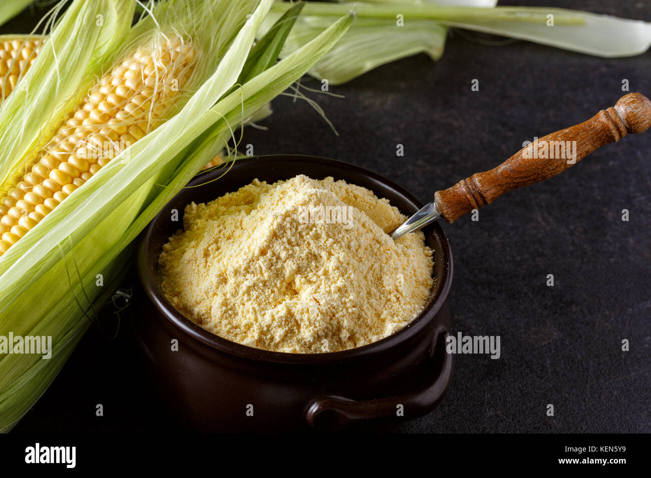 corn grits in bowl and fresh corn on black table background Stock Photo ...