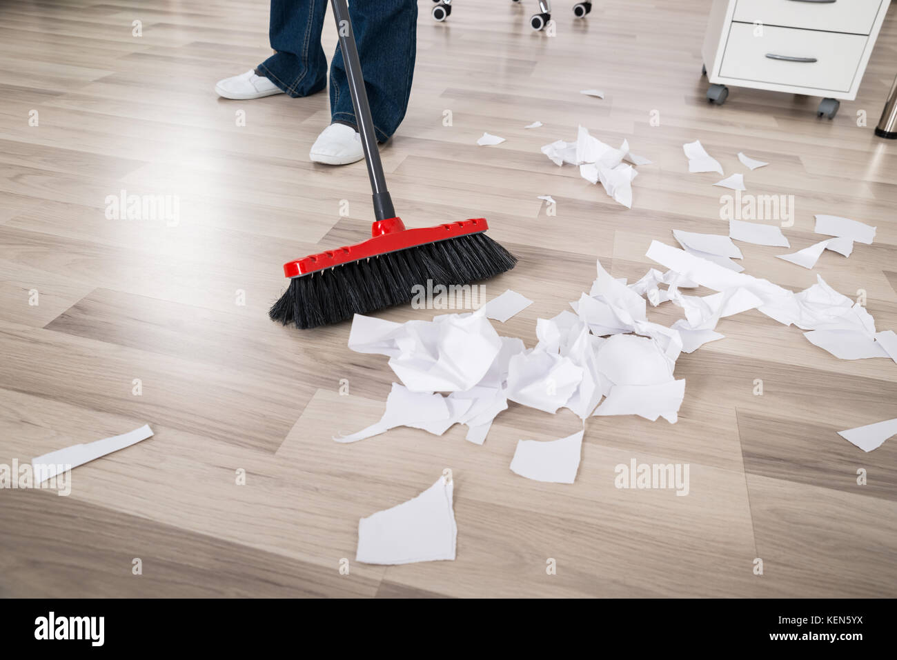 Close-up Of A Janitor Sweeping Torn Paper Pieces On Hardwood Floor ...