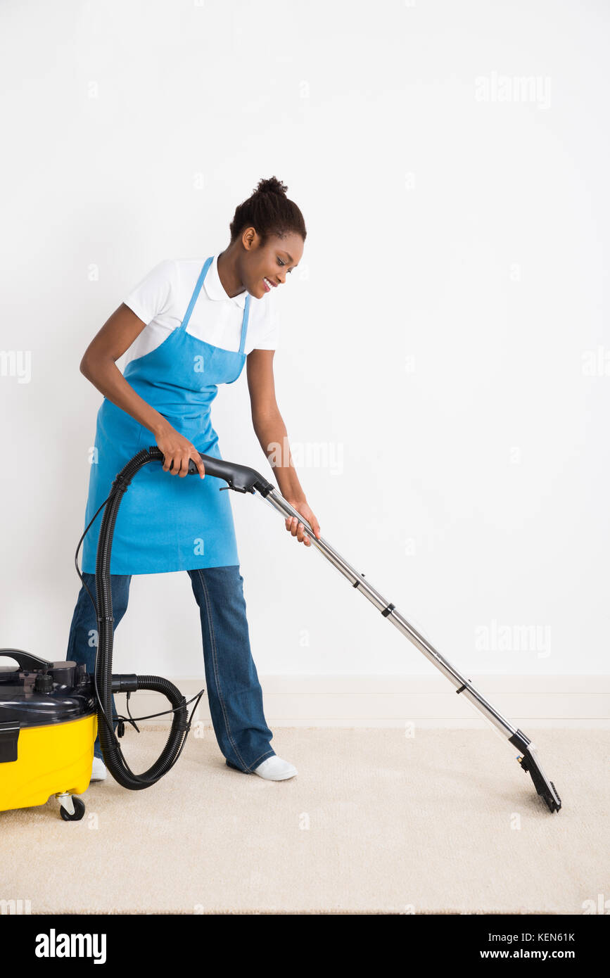 Happy black woman vacuuming hi-res stock photography and images - Alamy