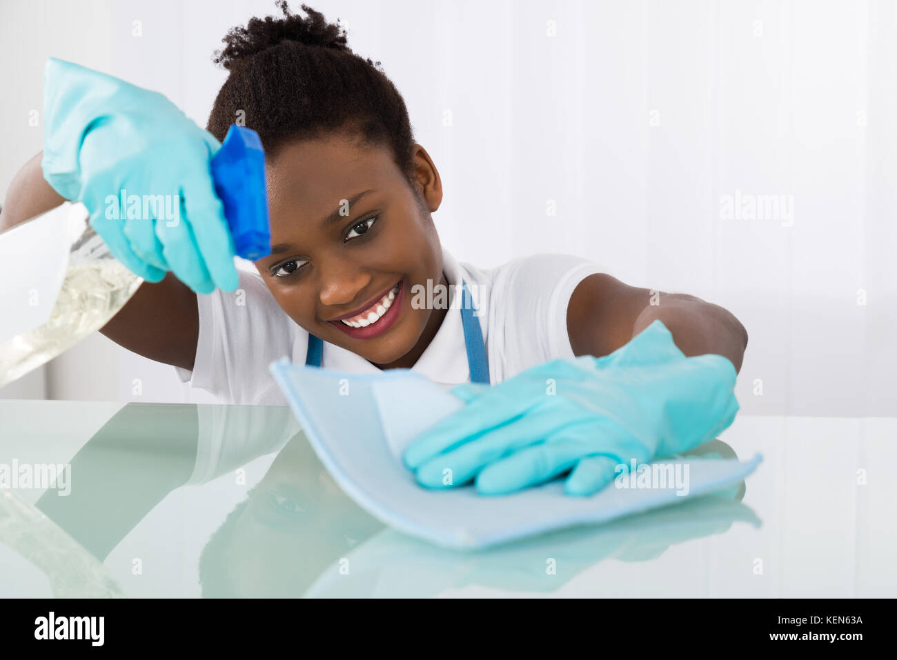 Close-up Of Young Happy Female Janitor Cleaning Desk With Rag Stock ...
