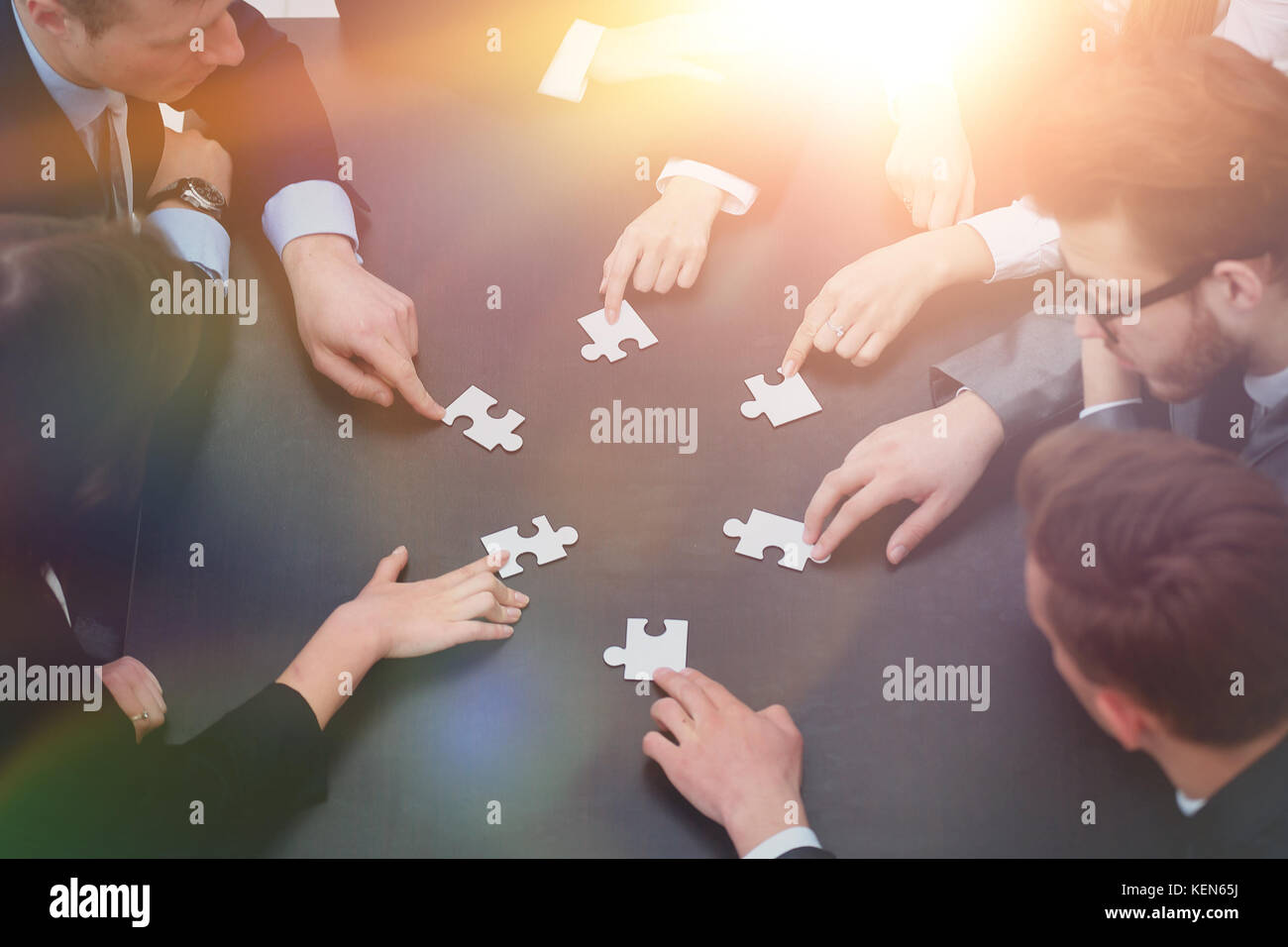 business team solving puzzle together Stock Photo - Alamy