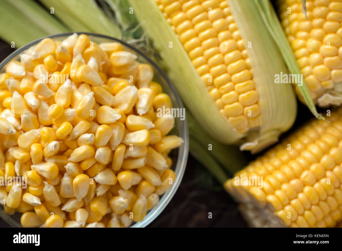 Fresh corn on cobs and corn grain in bowl on rustic wooden table Stock ...