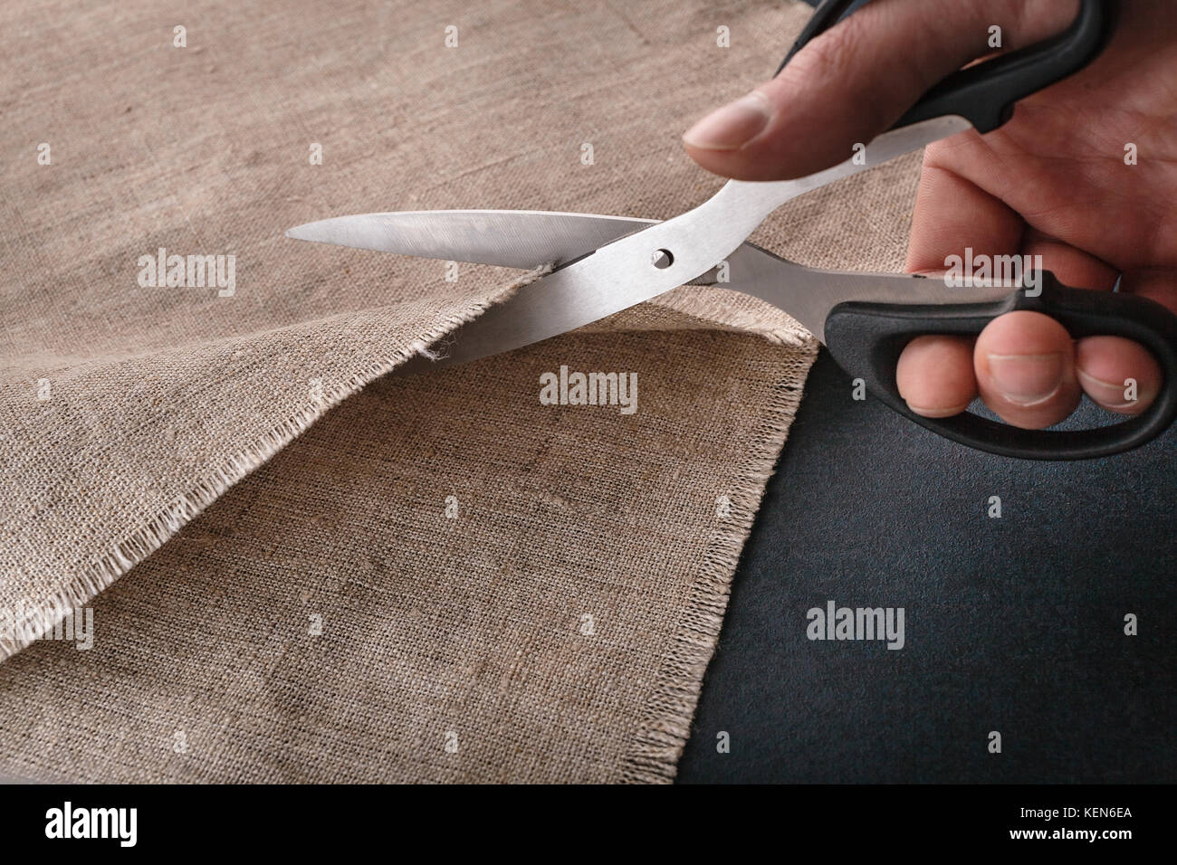 A man's hand cuts linen cloth with tailor's scissors Stock Photo - Alamy