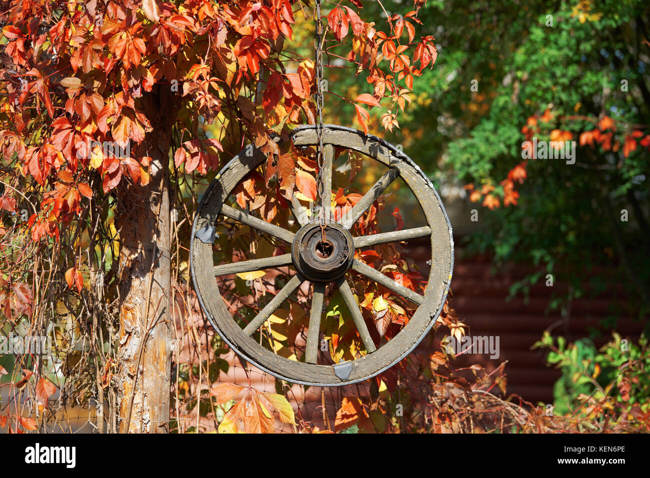 Autumn decor with wooden wagon wheel Stock Photo - Alamy