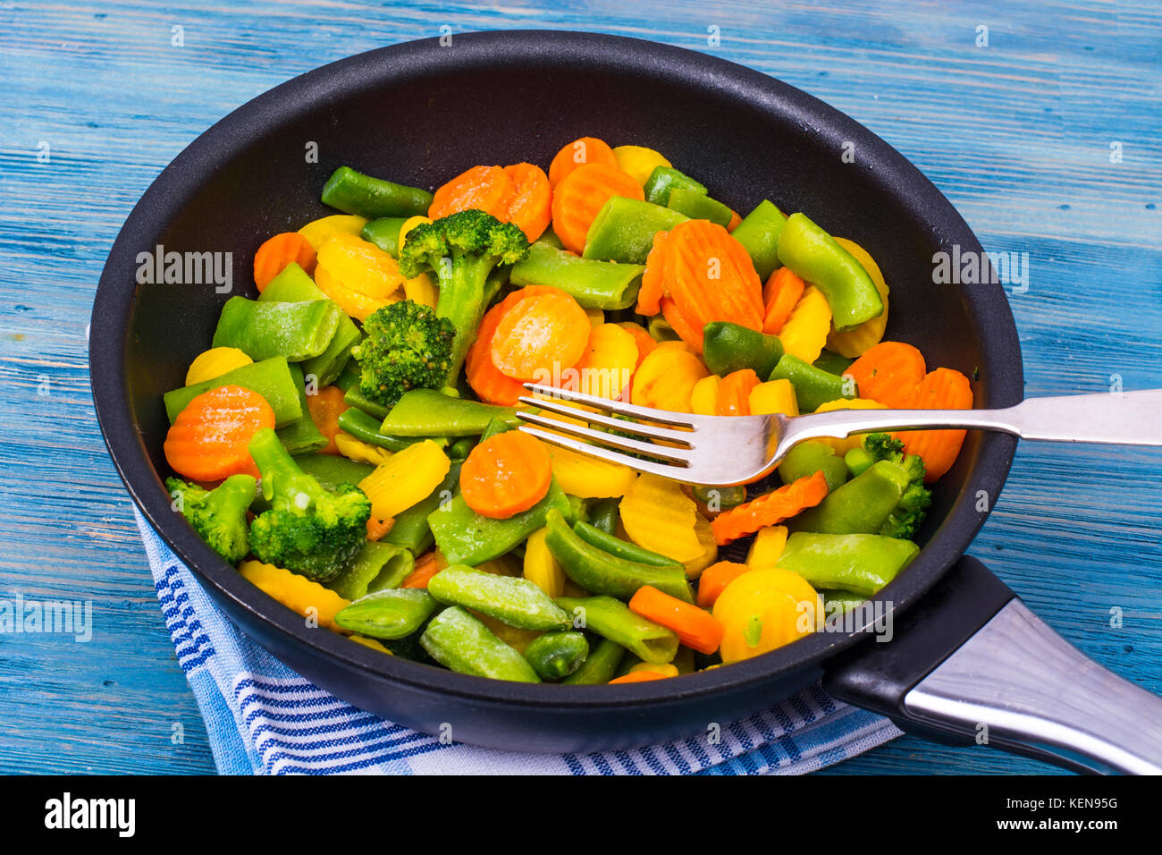 Food for vegetarians. A mix of vegetables on blue background. Studio ...