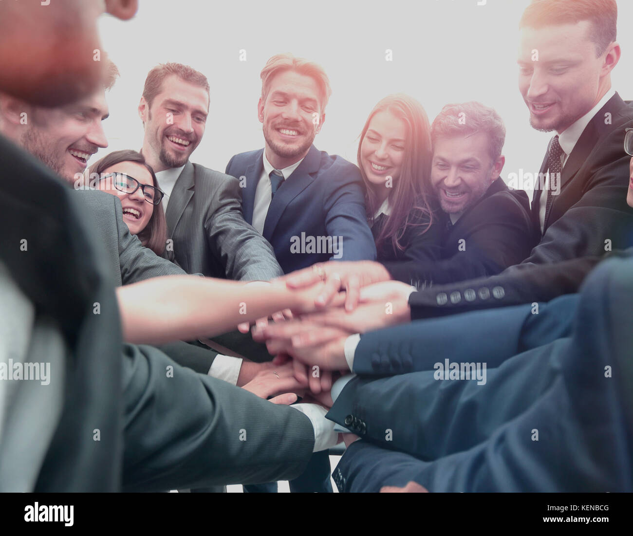 Large successfull business team showing unity with their hands together ...