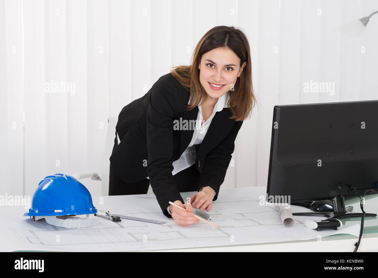 Young Happy Female Architect Working On Blueprint In Office Stock Photo ...