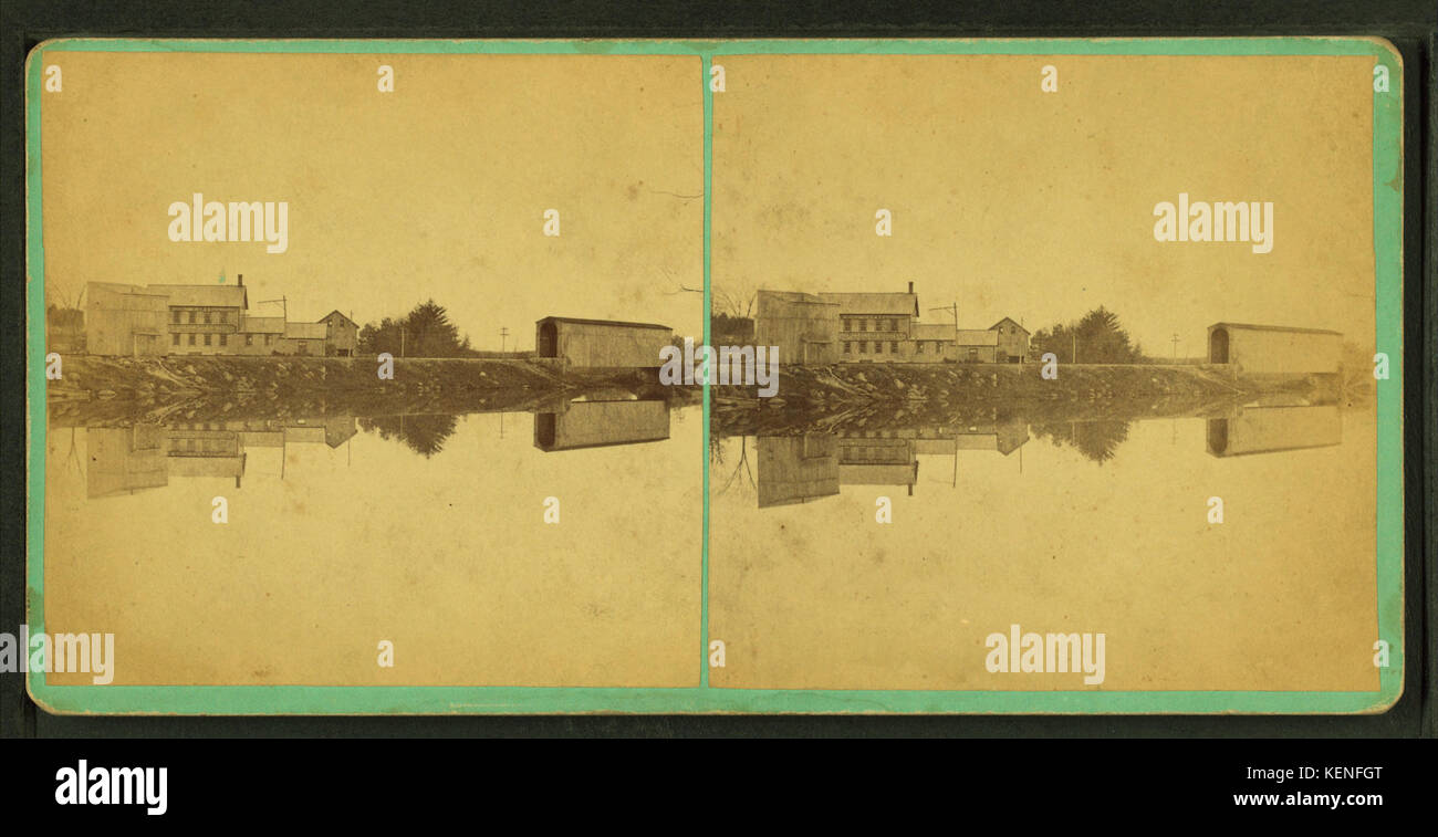 View of unidentified buildings, including a covered bridge, reflected ...