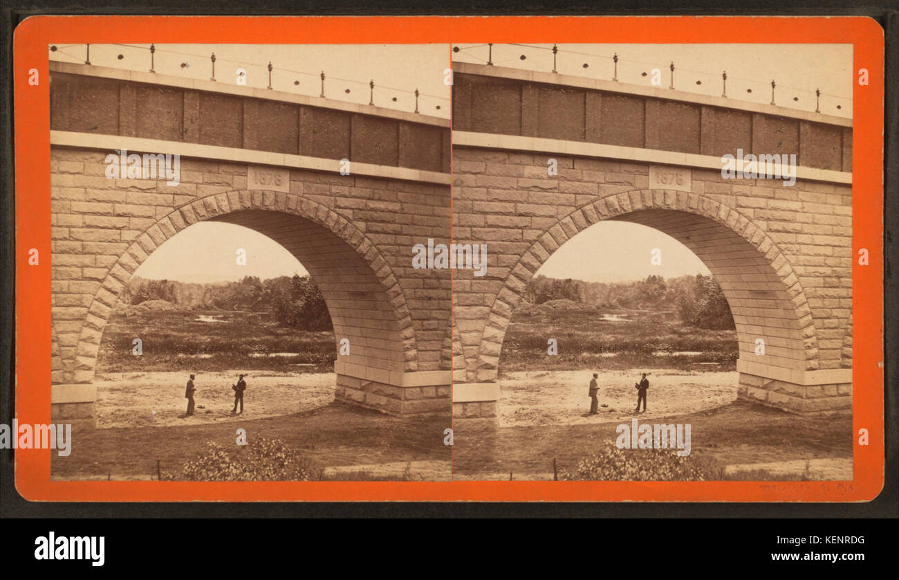 View of two people standing under completed arch, from Robert N. Dennis ...